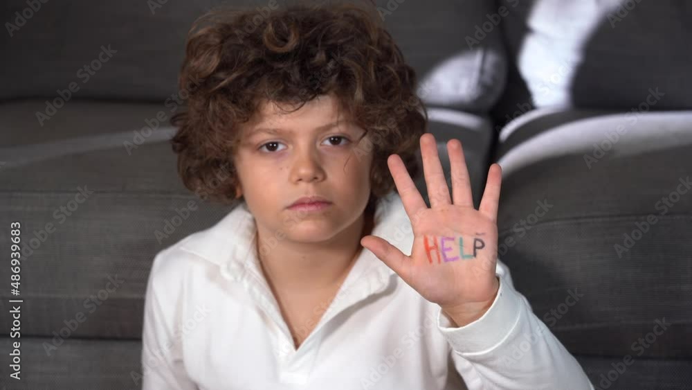 7 year old little boy alone with stop and help written on his hands ...