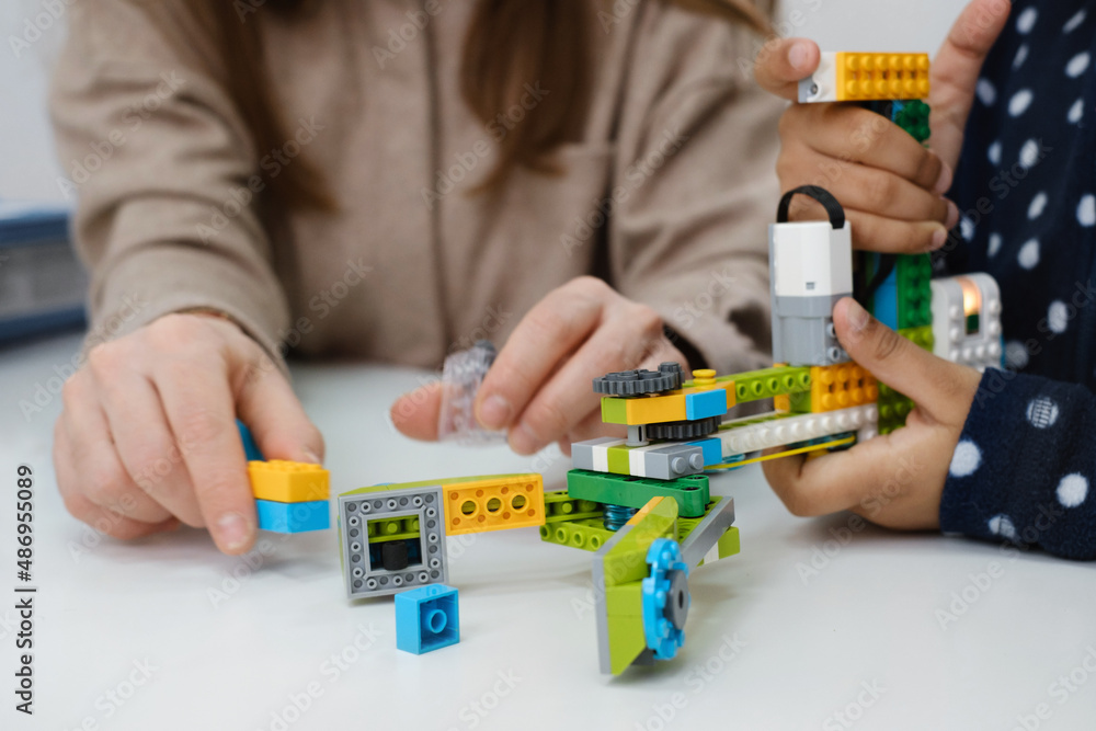 Coding Class, school girl constructing robot arm mechanism. multiethnic ...