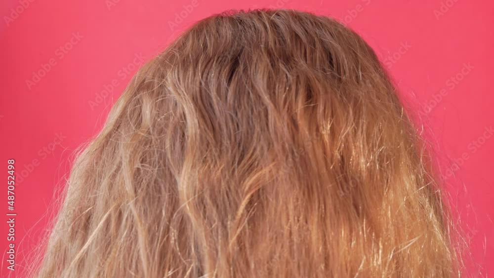 Girl combing dry tangled wavy hair with brush in hand close-up 4k ...