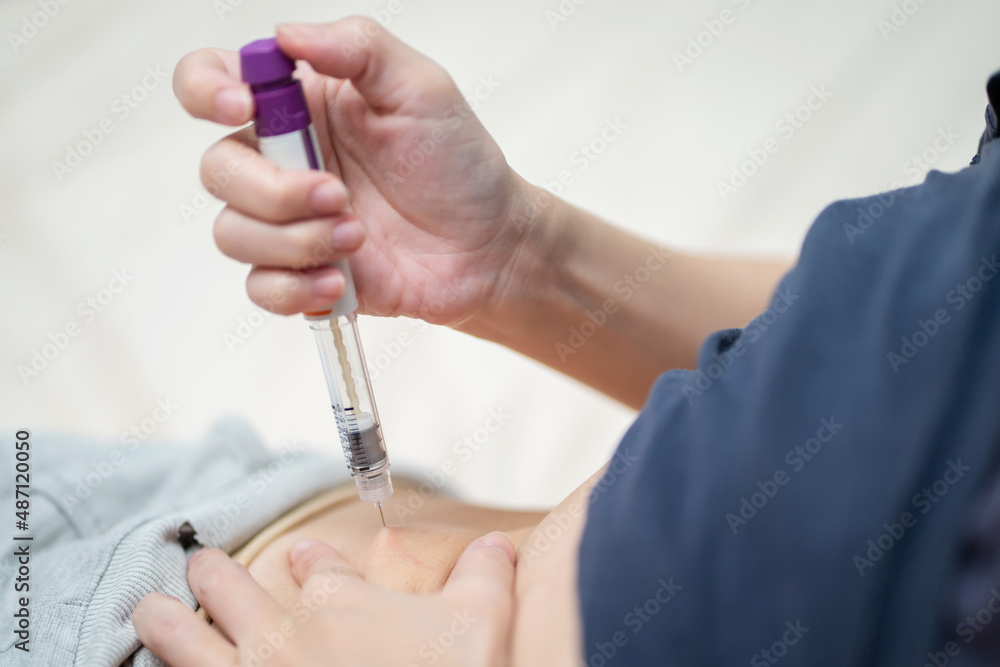 A woman finish the injection hormones at stomach or belly by using ...