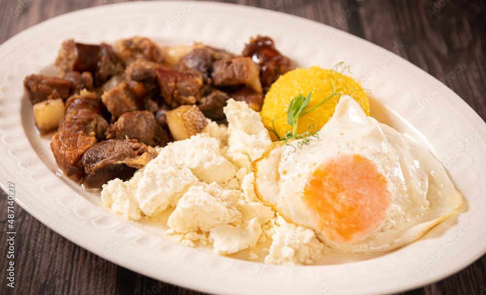 Traditional Romanian food called tochitura made of fried eggs, polenta ...