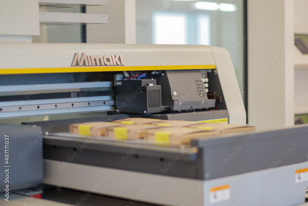 Printing machines in production. Mimaki logo on UV flatbed printer ...