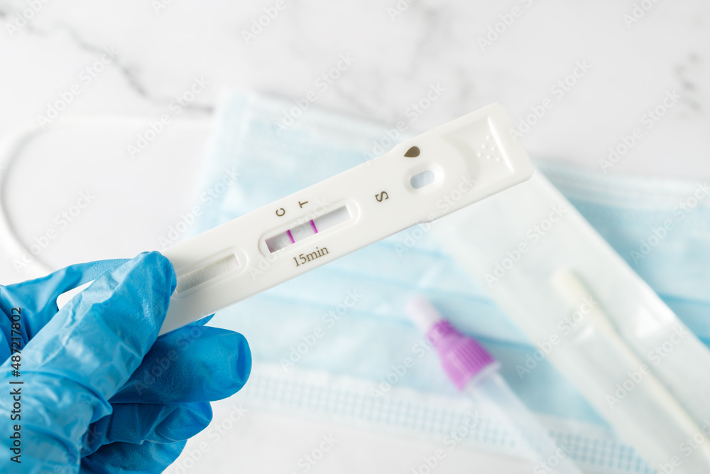 Hand showing Covid-19 positive result of rapid antigen test SARS CoV-2 ...