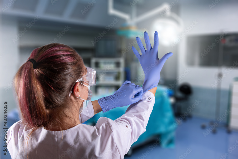 Cirujana preparandose para operación, colocando sus elementos de ...