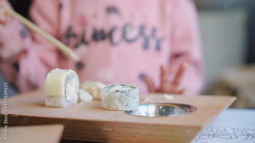 Child eat sashimi in restaurant. Middle shoot little girl eating sushi ...