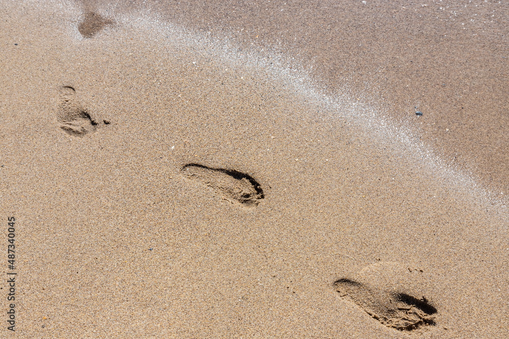 Footprints of a man on the yellow beach sand from walking barefoot by ...