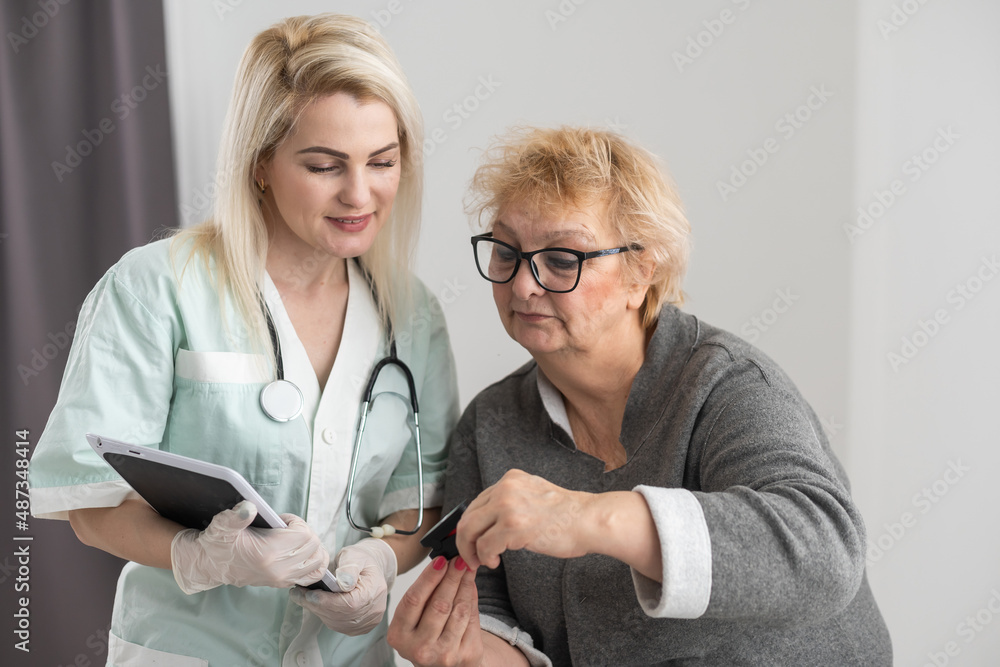 Female caregiver with fingertip pulse oximeter,attached on finger of ...