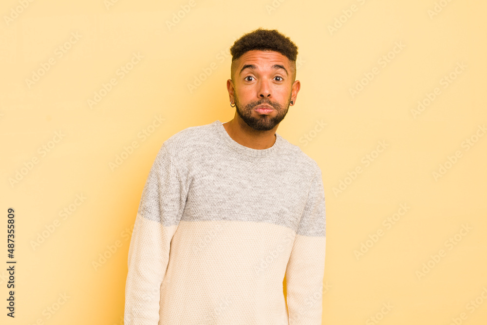 young afro man with a goofy, crazy, surprised expression, puffing ...
