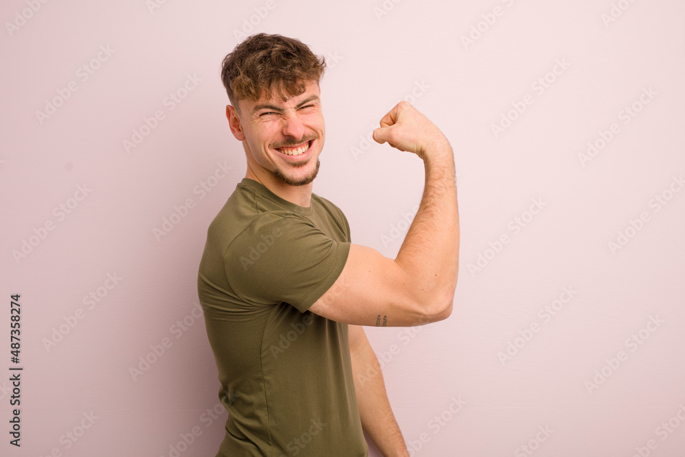 young cool man feeling happy, satisfied and powerful, flexing fit and ...