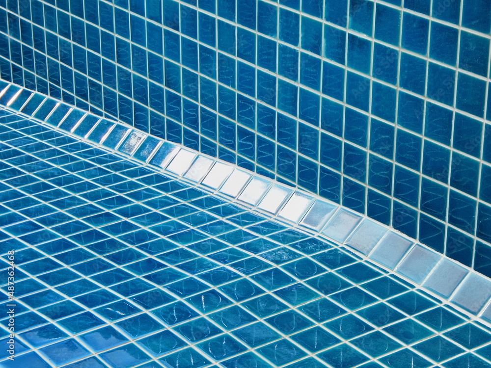 Tiled pool. The man hand while using spacer for installing tiles ...