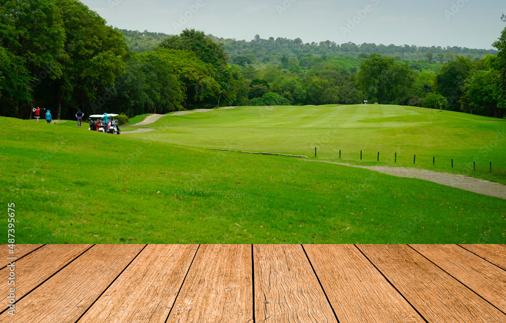 Wooden floor and golf course background. Fresh spring green golf course ...