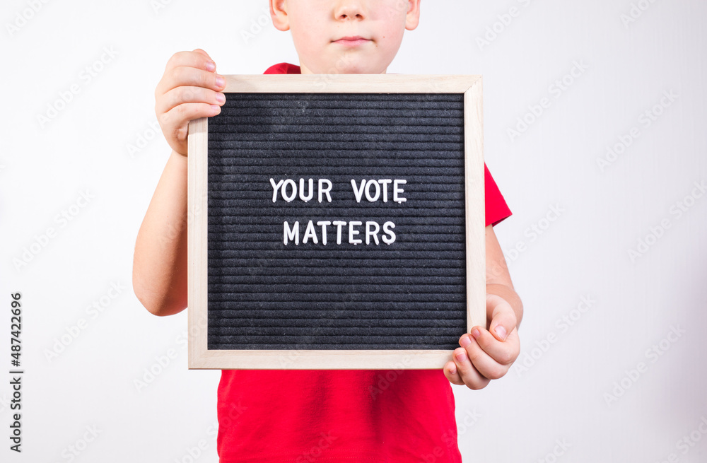 kid boy holding letter board with text Your Vote Matters on white ...