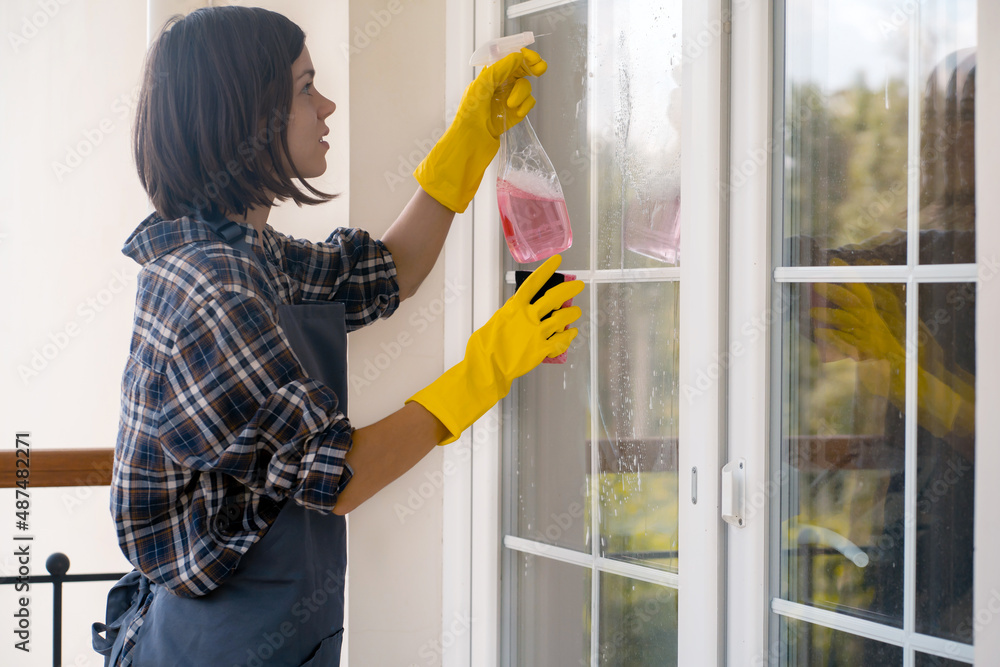 Young girl washes the windows. Stock Photo | Adobe Stock