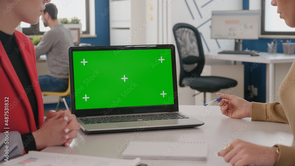 Close up of colleagues using laptop with green screen on desk, women ...