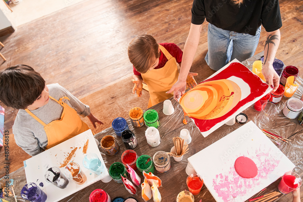 Little kids drawing pictures with fluid art technique together at the ...