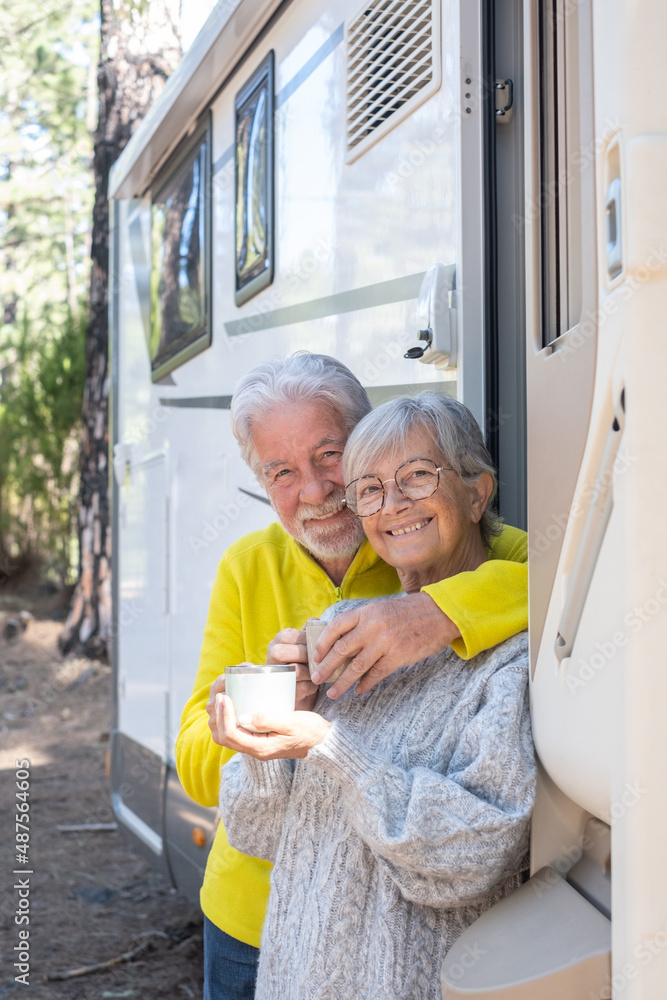 Happy relaxed caucasian senior couple leaning outdoor at their camper ...