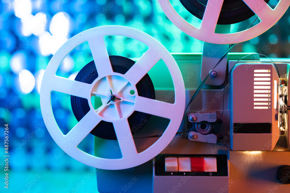 Retro reel with film rotating on colorful shining sparkles wall. Old ...