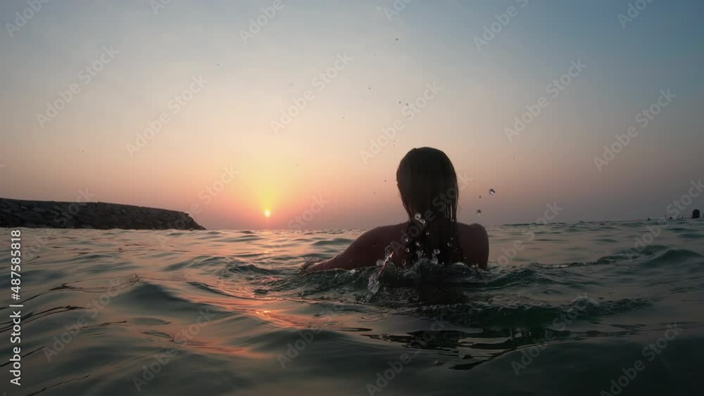 Back view. girl dives into the sea. Underwater video. Woman underwater ...