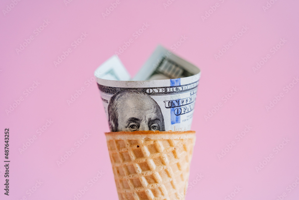 Benjamin Franklin peeks out of a waffle cone, hundred dollars in a ...