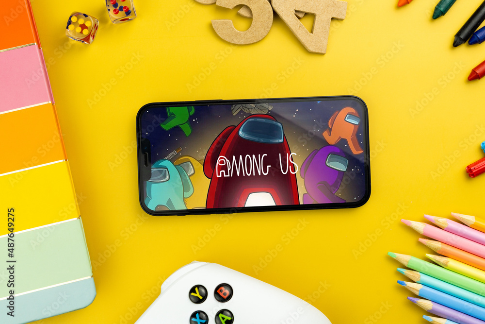 Among Us mobile game app on the smartphone screen. Yellow background ...