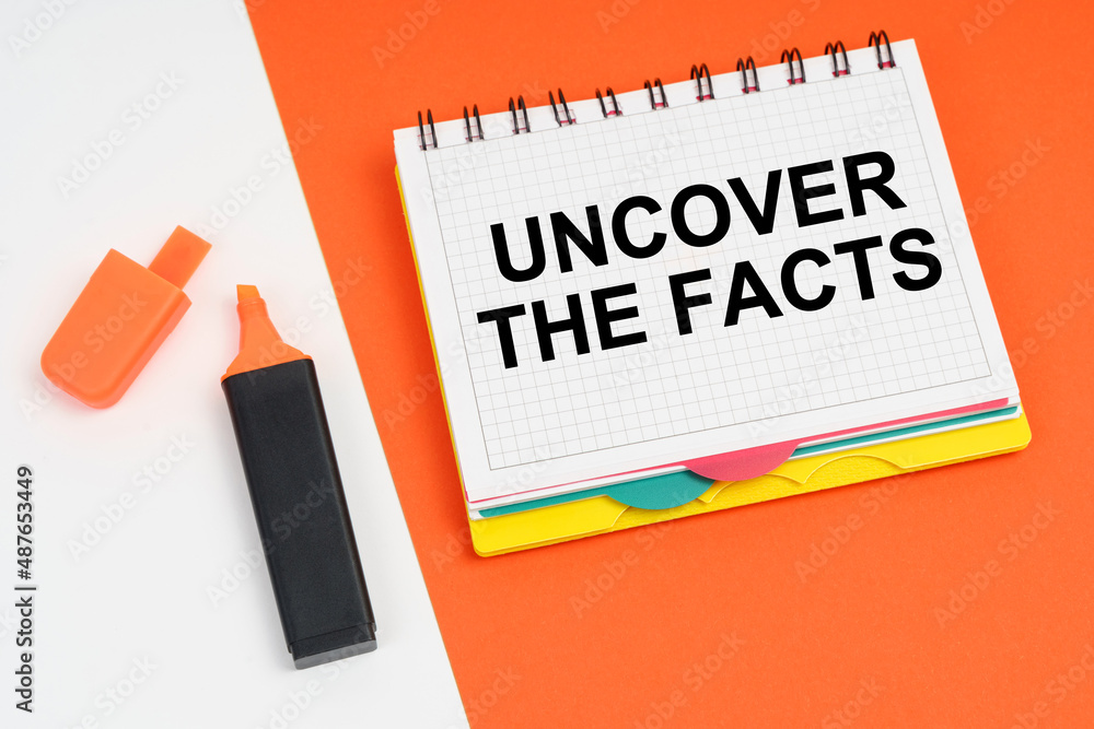 On a white-orange surface lies a marker and a notepad with the ...