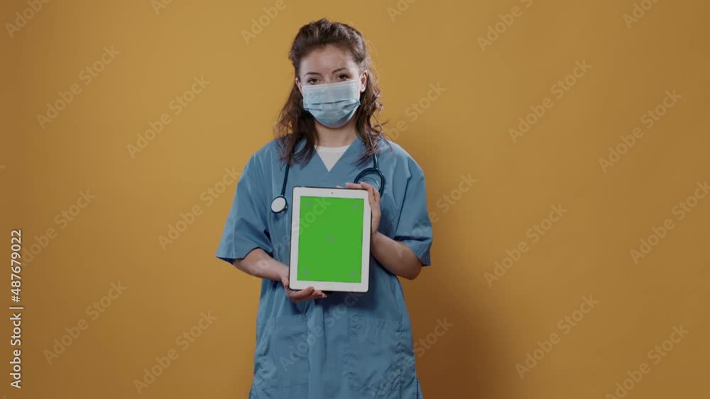 Confident caucasion doctor posing holding digital tablet with green ...