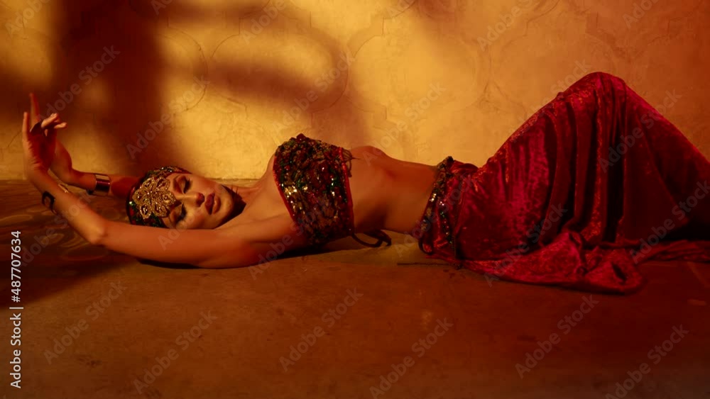 seductive belly dancer woman is lying on floor and moving her belly slowly, alluring dance Stock ...