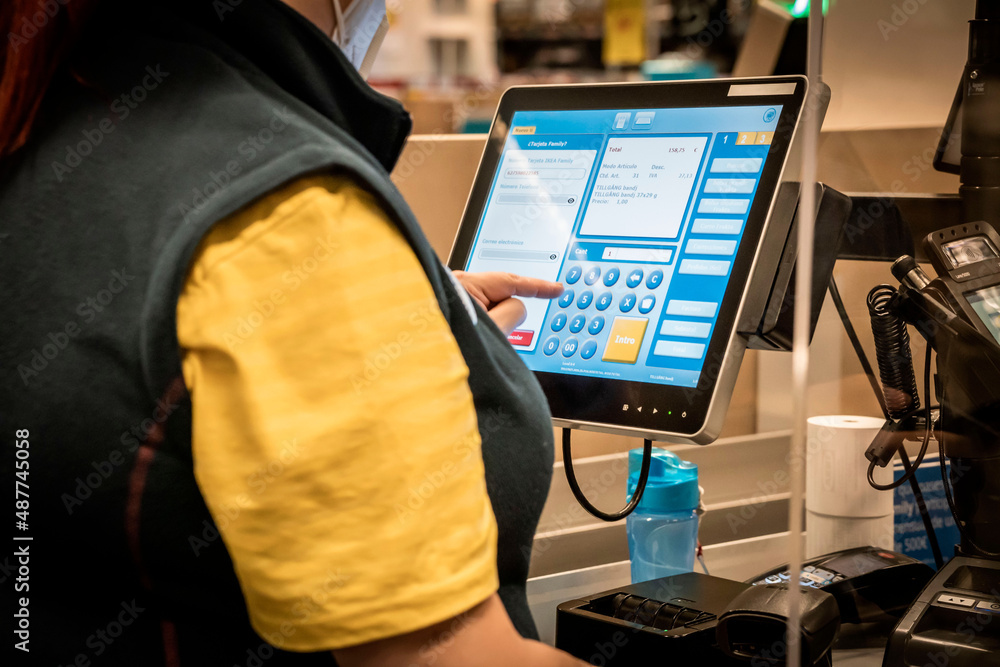 Medium close-up, female cashier and shop assistant putting the barcode ...