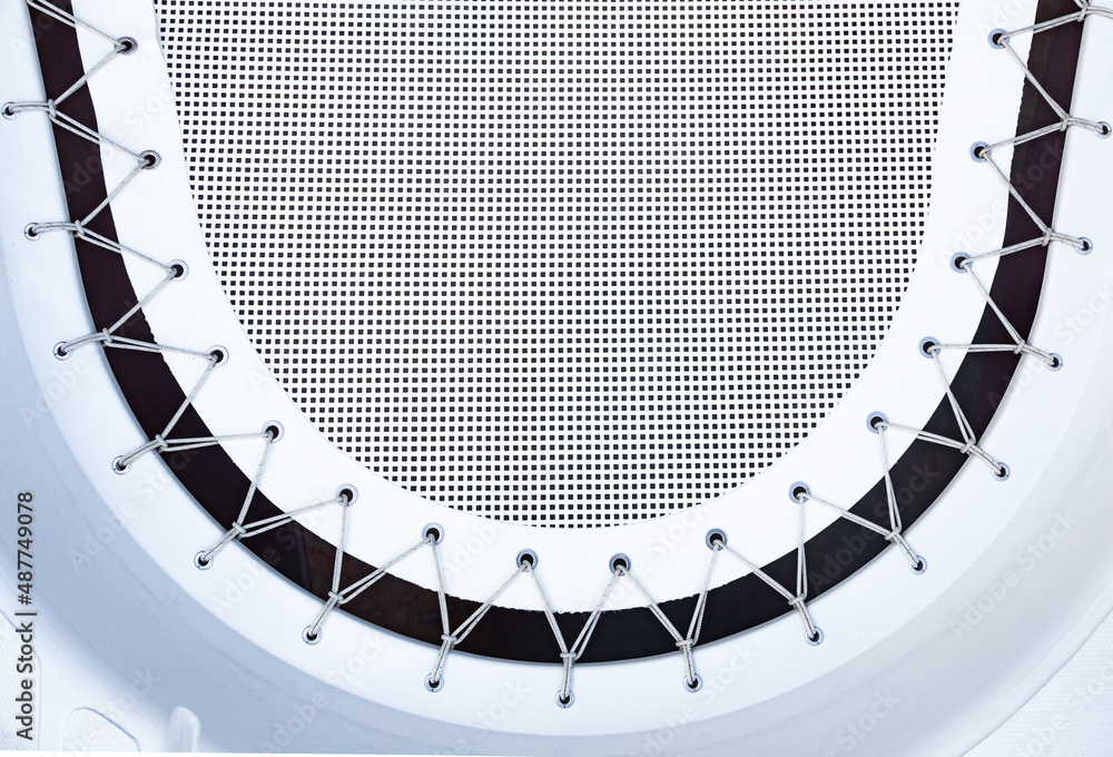 Part of a stretched white net with ropes threaded into loops on the ...