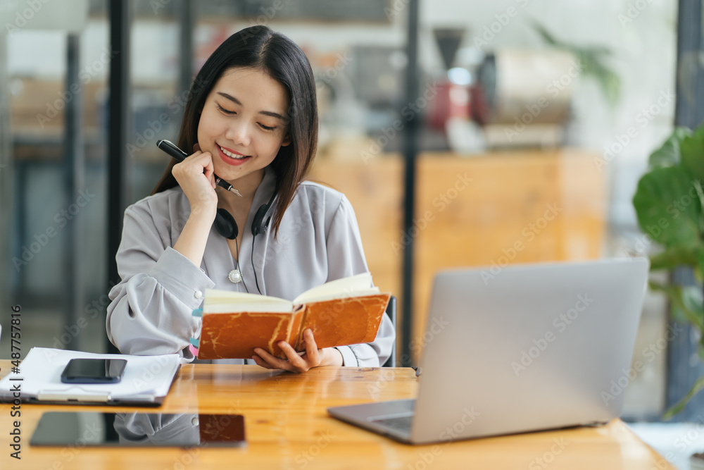 Young asian woman taking down notes in diary. Female university student ...