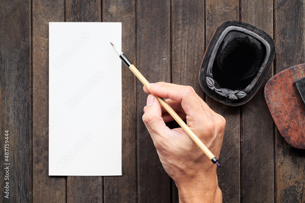 Abstract man hand white paper with bamboo calligraphy brush and ...