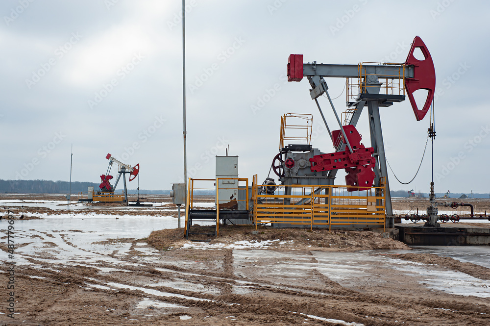 Crude oil pump jack at oilfield on sunset backround. Fossil crude ...