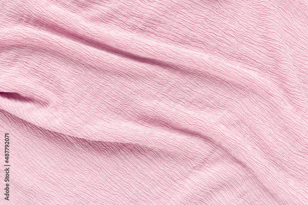 Soft pink crumpled fabric with puckered texture twisted in spiral ...