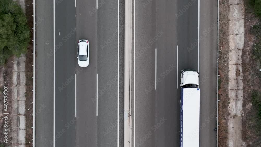 A vertical aerial shot above the 6 lane road, where vehicles are ...