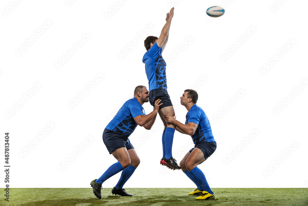 Dynamic portrait of male rugby players playing rugby football on grass ...