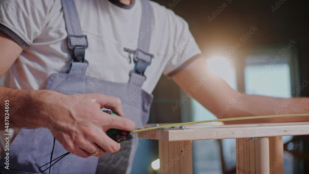 Close-up of builder using a tape measure and writing wood construction ...