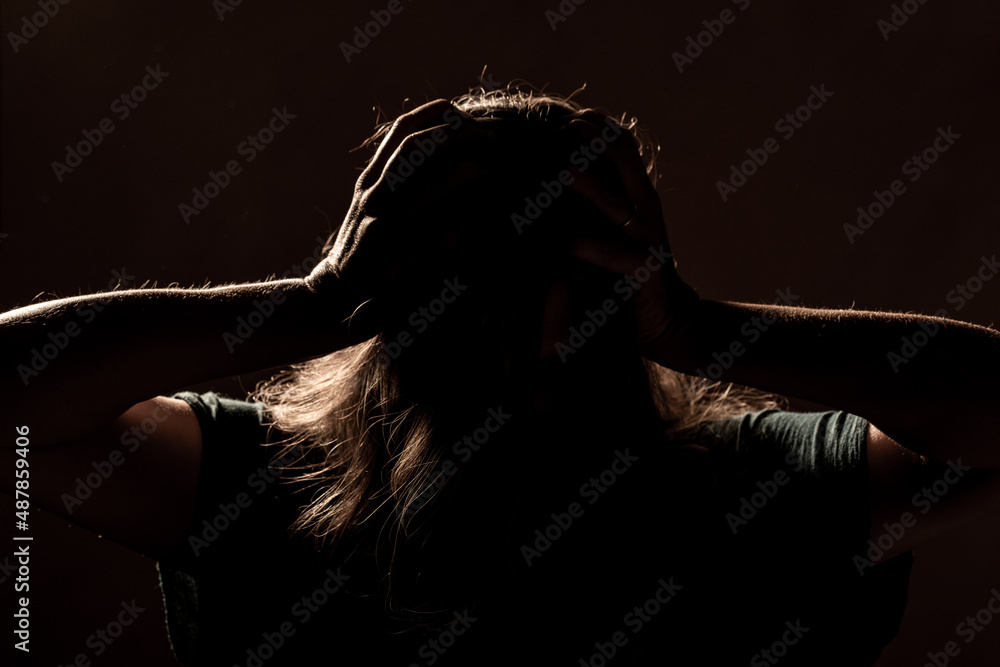 Half face of unrecognizable woman in shadow shrouded in darkness ...