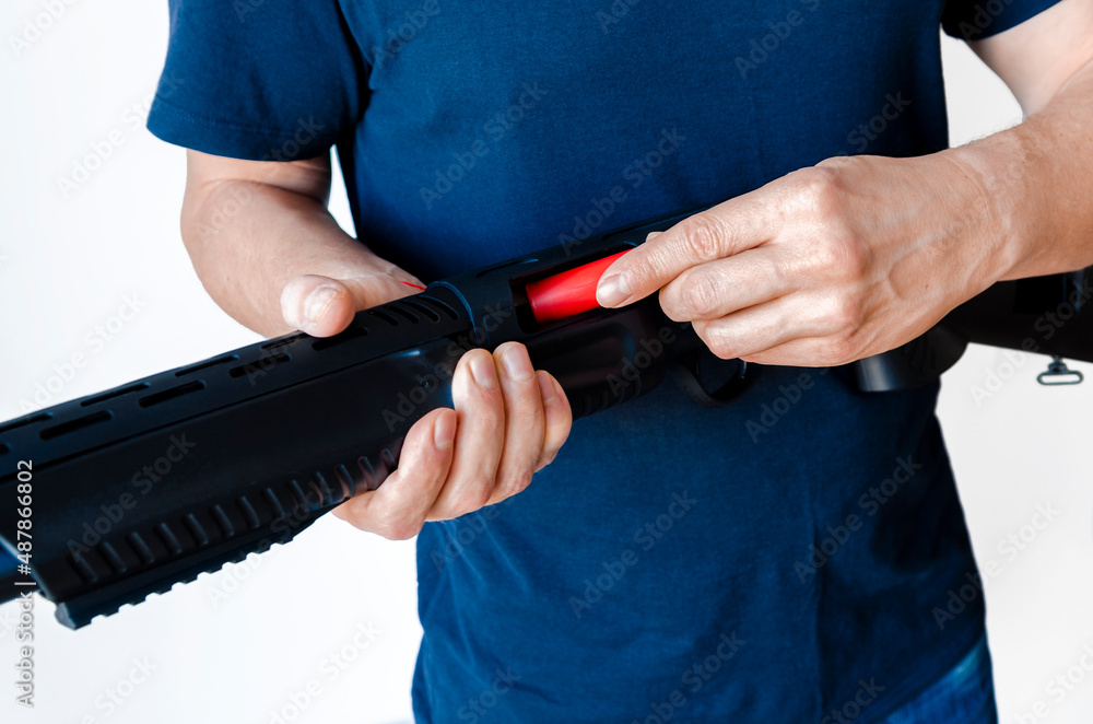 The man charges the shotgun with ammunition. Charging a pump smoothbore ...