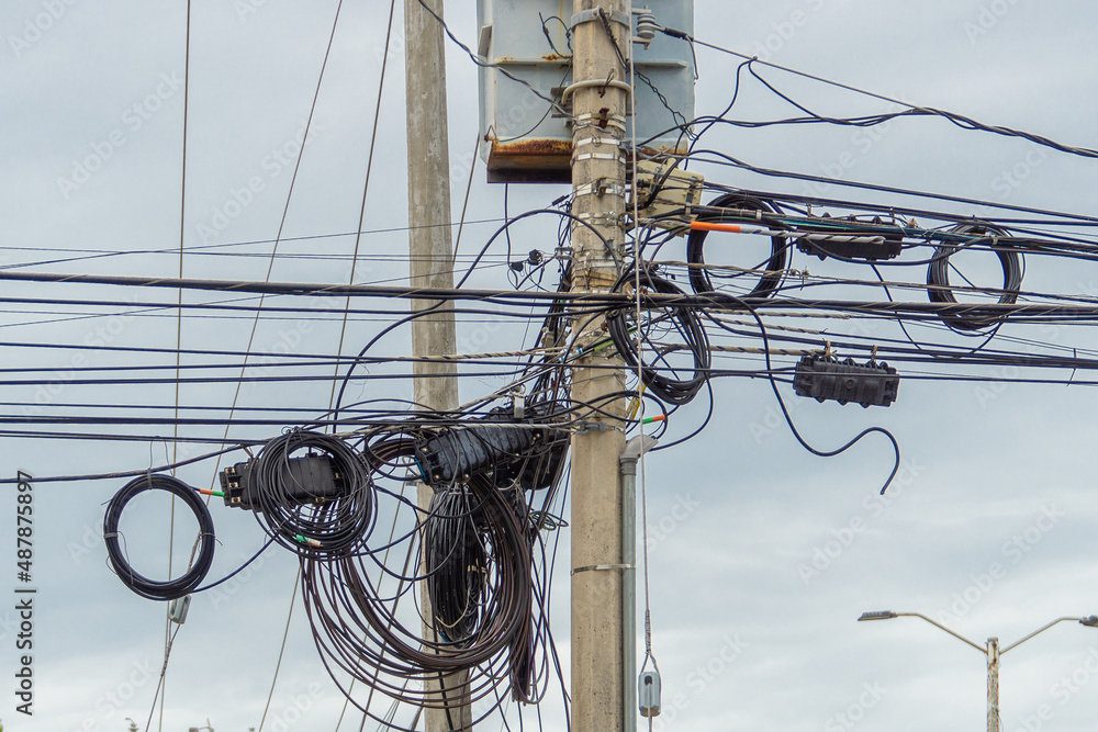 Chaos of cables and wires on an electric pole. Many electrical cable ...