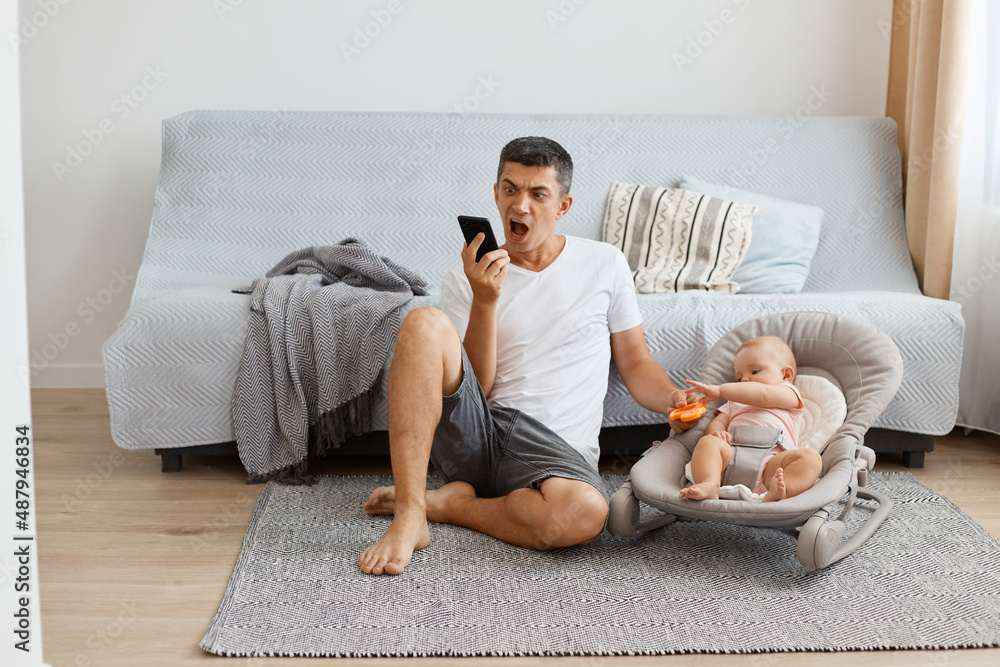 Horizontal shot of angry man wearing white casual style T-shirt and ...