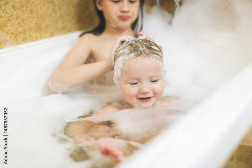 Cute sibling children bathe in a bubble bath together. Children in the ...
