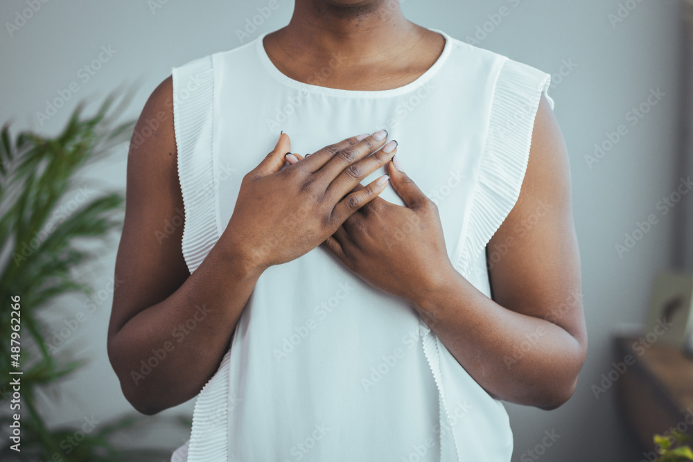 Cropped close up smiling grateful woman holding folded hands on chest ...