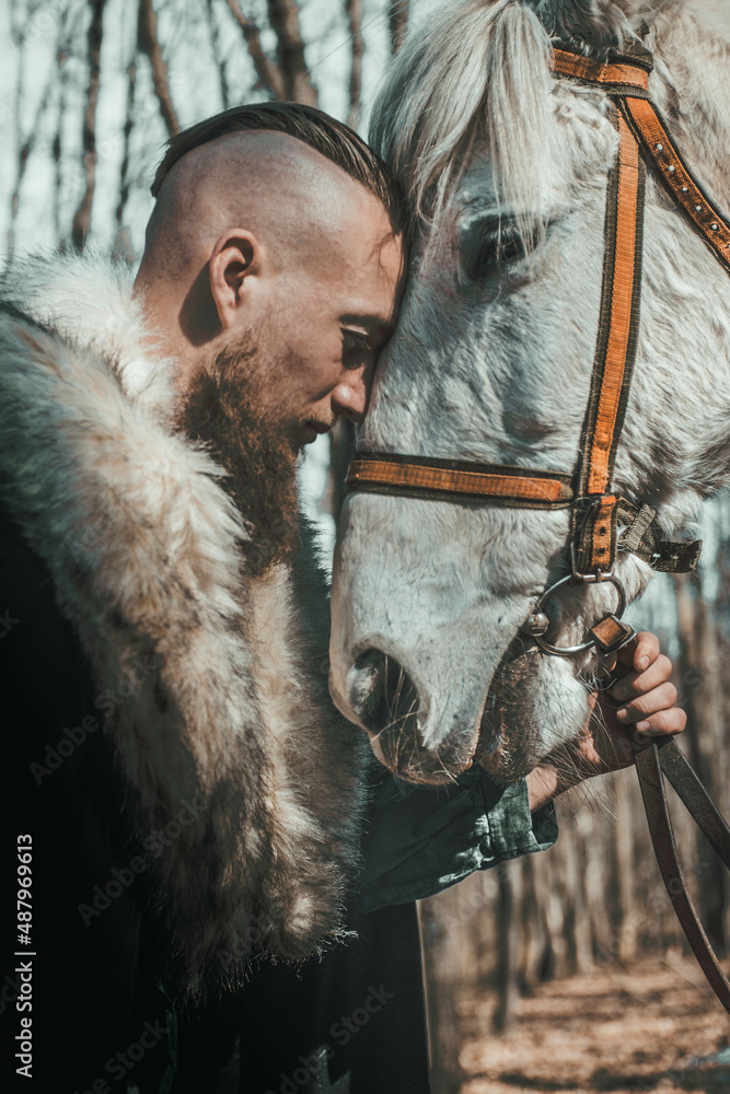 A medieval warrior Viking with a beard and a muscular physique poses in ...
