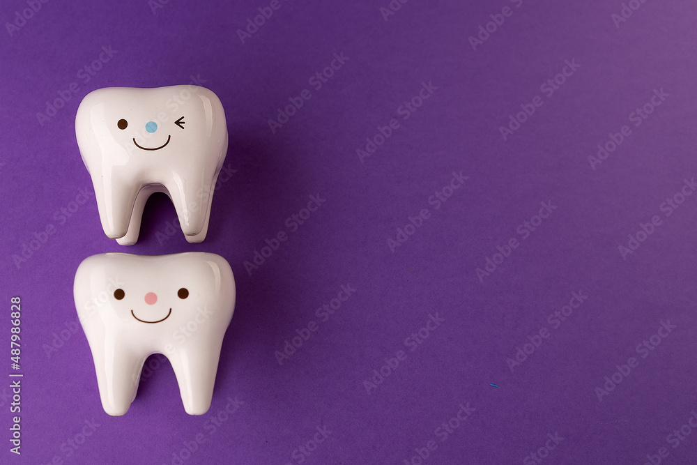 figurines of teeth on a purple background. top view. Copy space ...