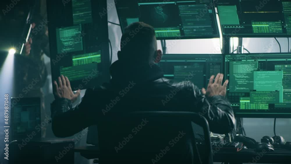 Male hacker raising hands behind head while police in uniform with guns ...