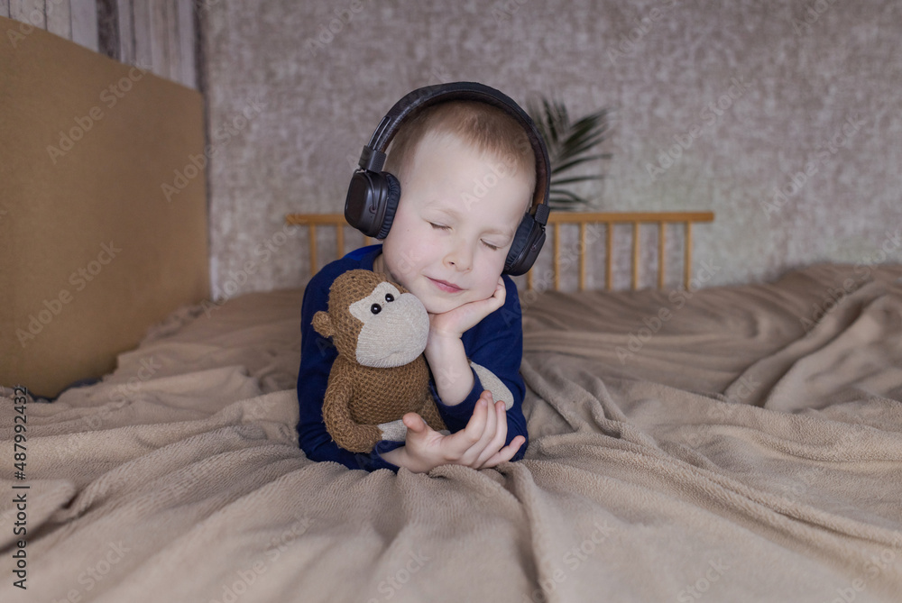 Boy in headphones listens to a meditation for children before going to ...
