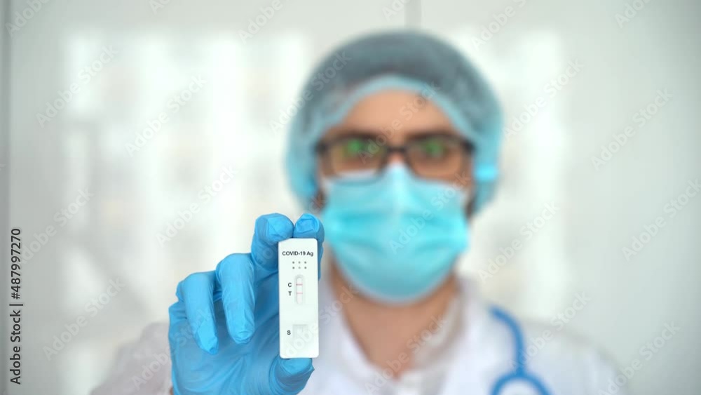 Male doctor in protective mask holds rapid antigen test for covid-19 in ...