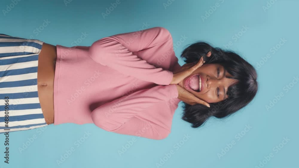Vertical video of impressed beautiful dark skinned woman looks with ...