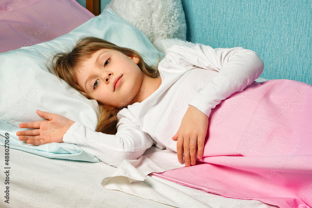 Schoolgirl woke up in the morning and lies in bed. Good healthy sleep ...