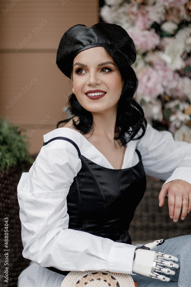 Beautiful disabled stylish Woman with artificial arm sitting in flower ...